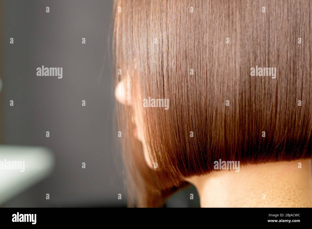 Close-up of hairdresser hand is combing short hair of woman in hair ...