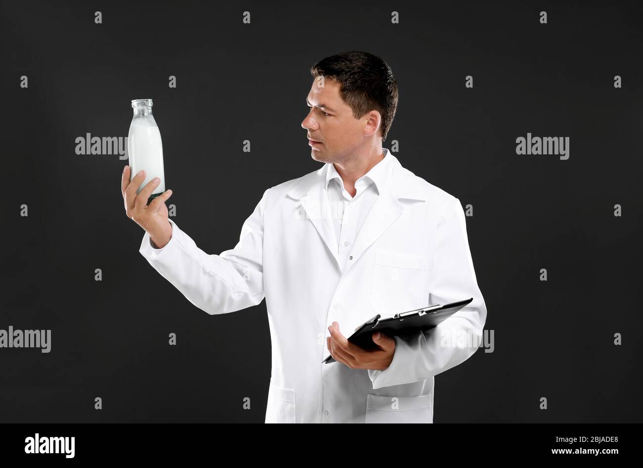 Male milk expert on dark background Stock Photo - Alamy