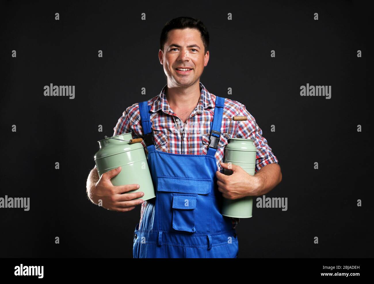 Handsome milkman on dark background Stock Photo - Alamy