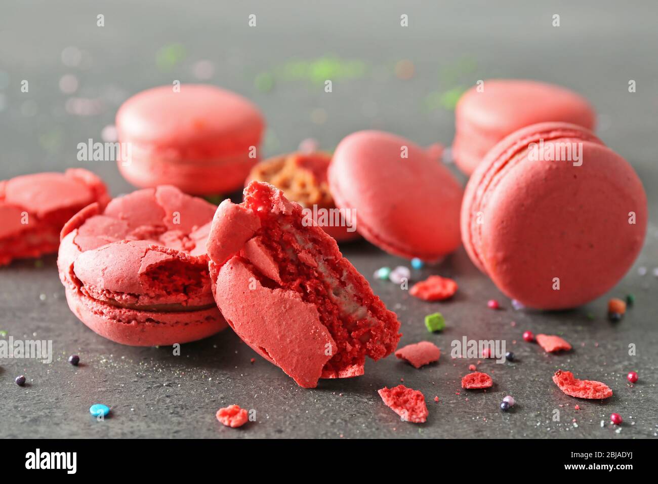 Red broken tasty macaroons on gray background Stock Photo - Alamy