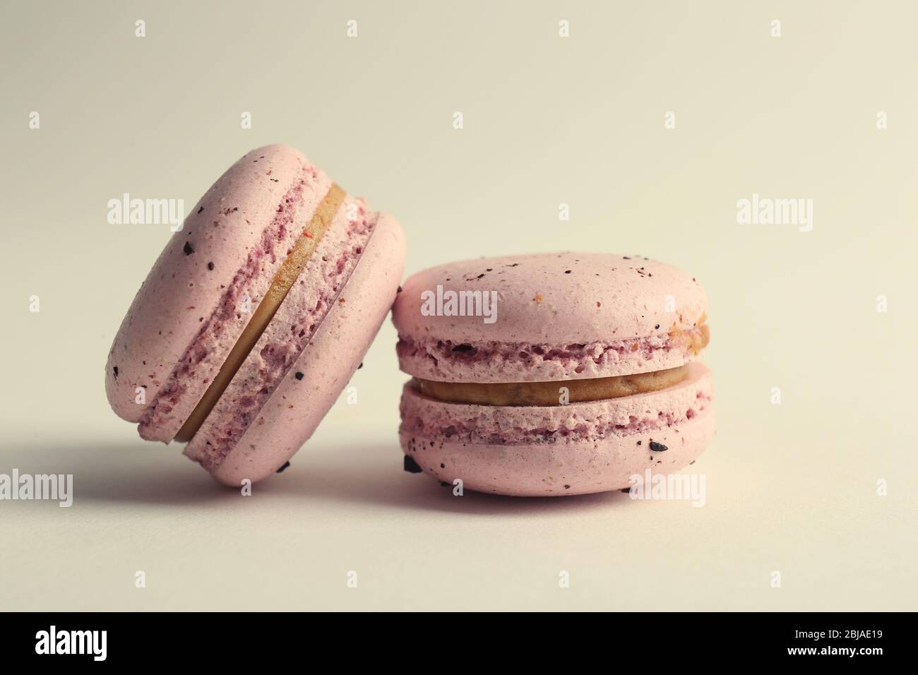 Pink tasty macaroons on white background Stock Photo - Alamy