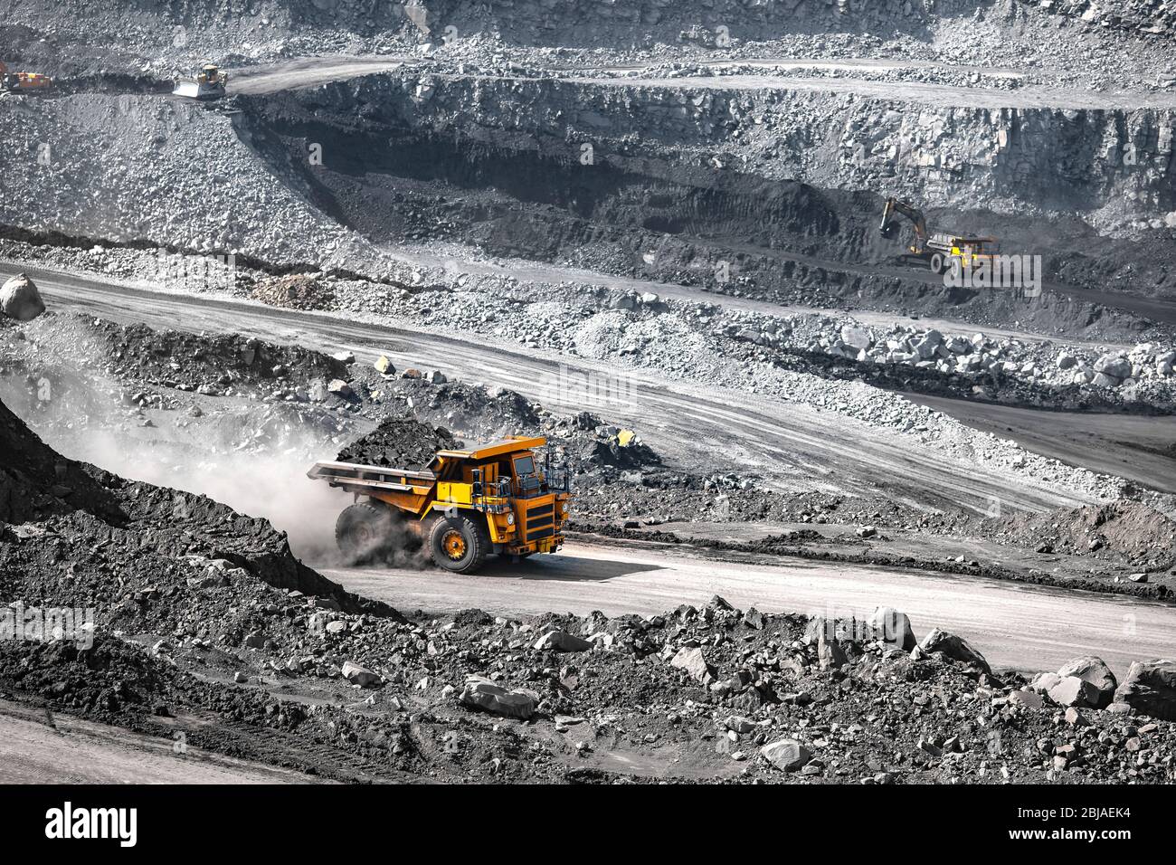 Open pit mine industry. Yellow mining truck for coal moves along dusty ...