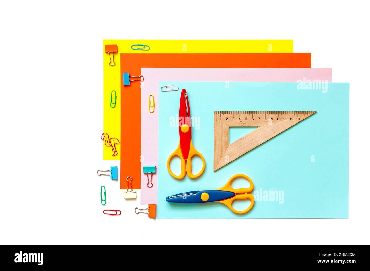 Sheets of colored paper arranged in a row, crayons, scissors and ...