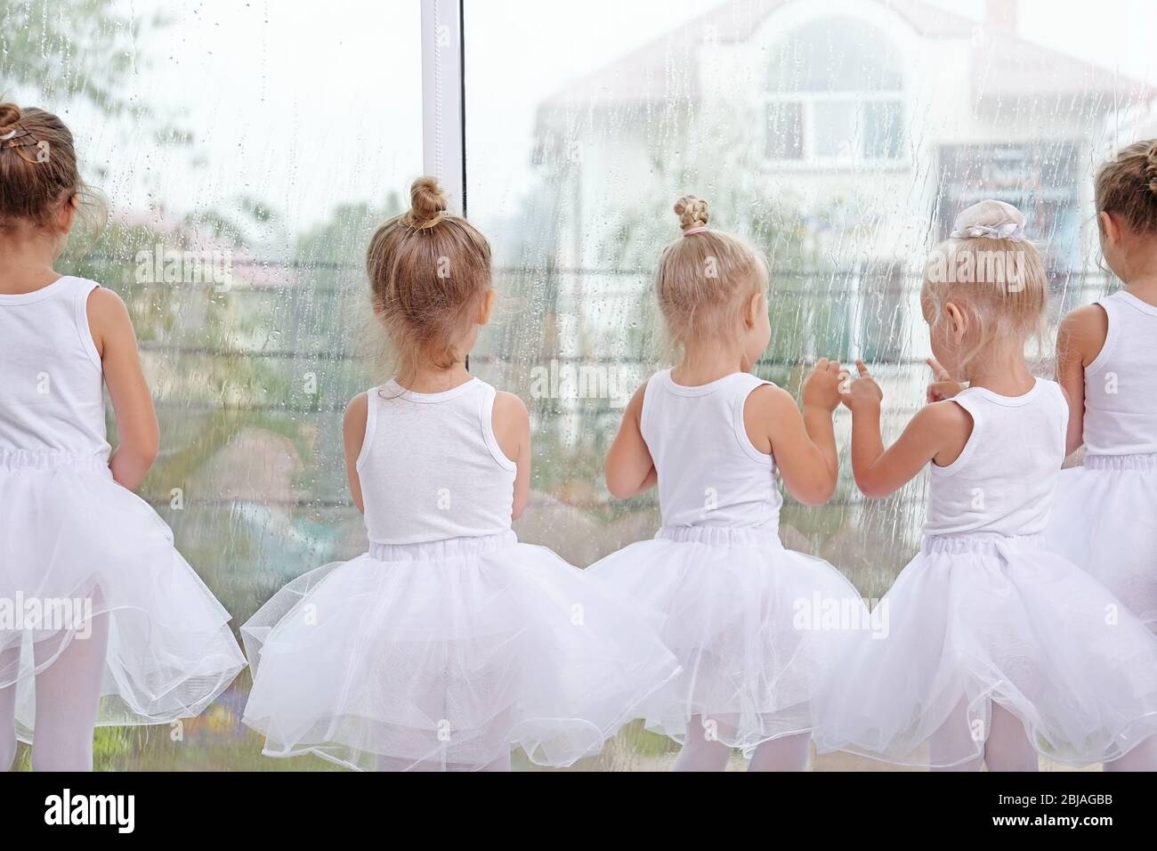 Cute girls standing near window in ballet class Stock Photo - Alamy