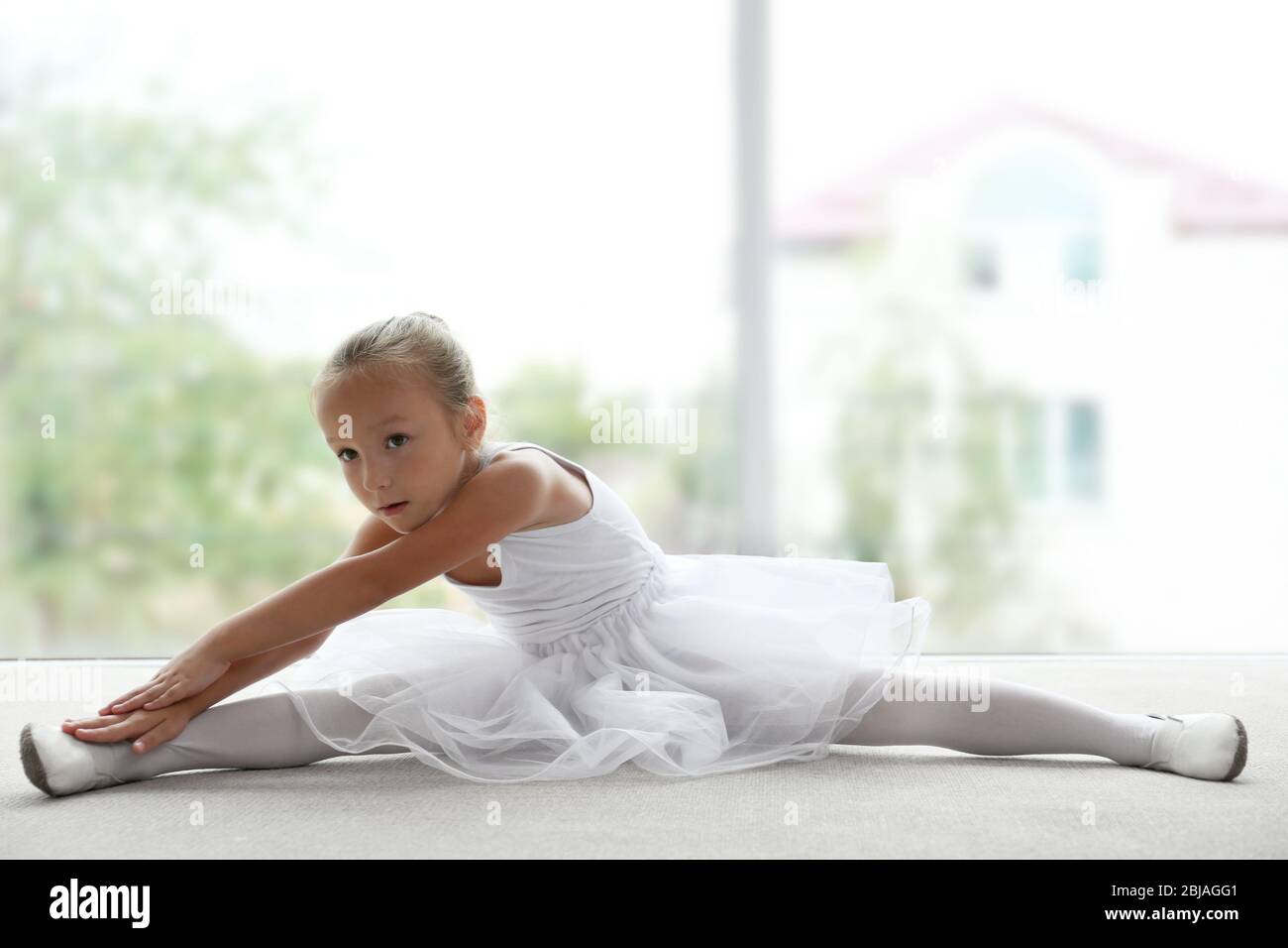 Cute ballerina sitting on the floor at ballet class Stock Photo - Alamy
