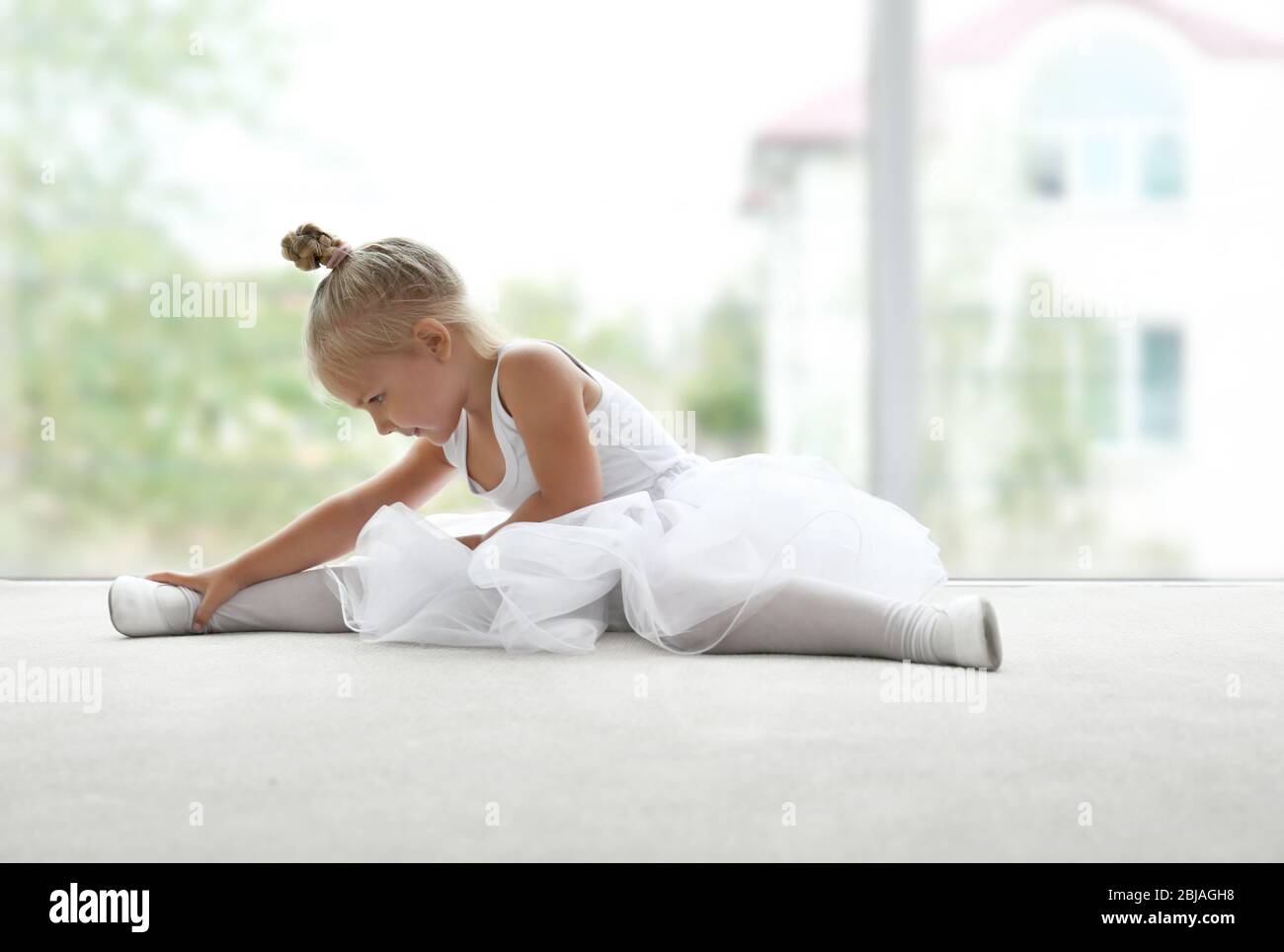 Cute ballerina sitting on the floor at ballet class Stock Photo - Alamy