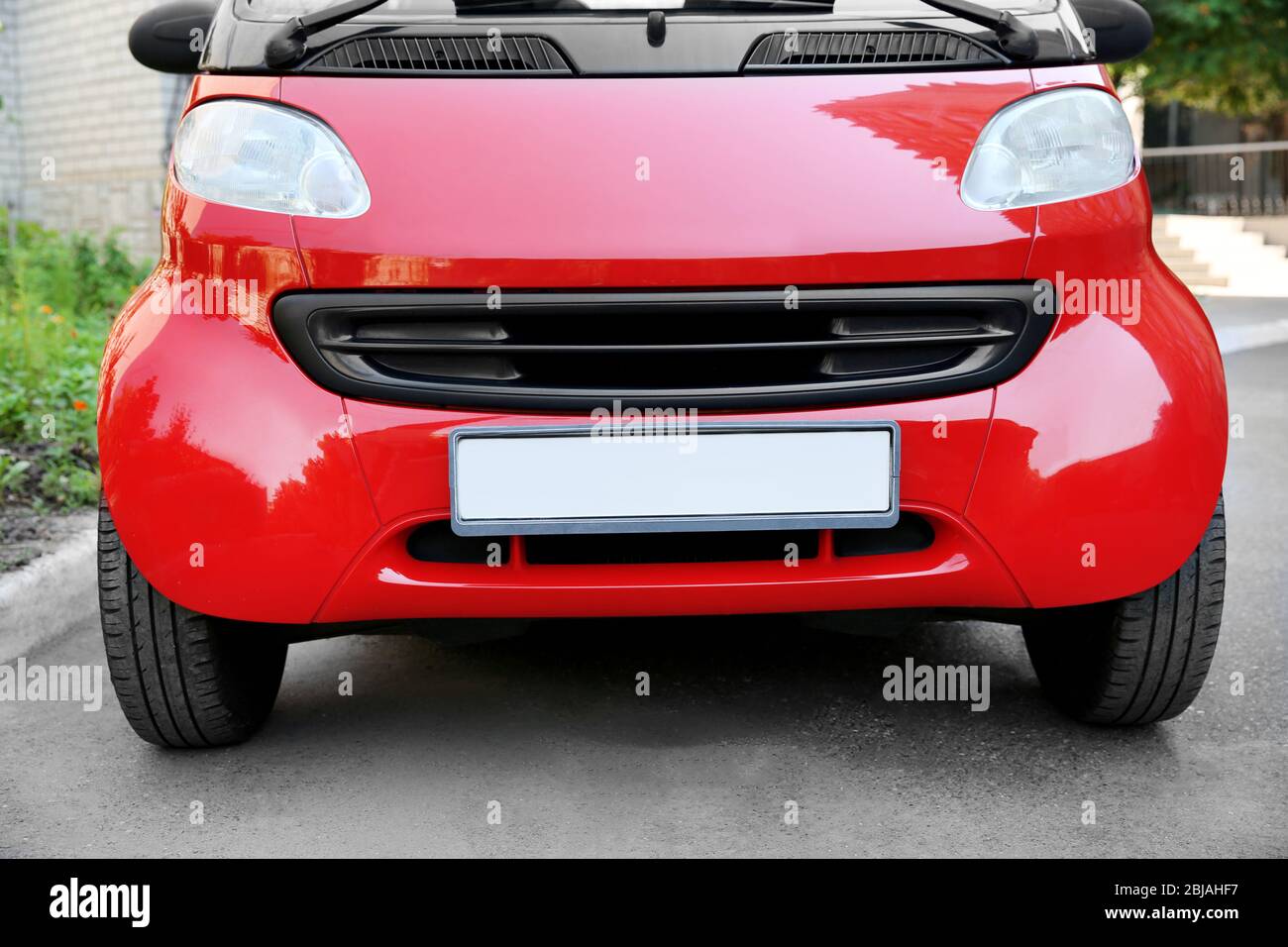 Red car on street Stock Photo - Alamy