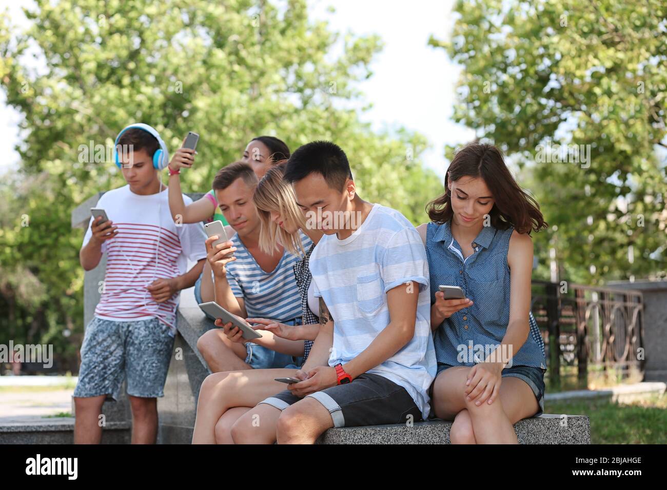 Teenagers with gadgets on street Stock Photo - Alamy