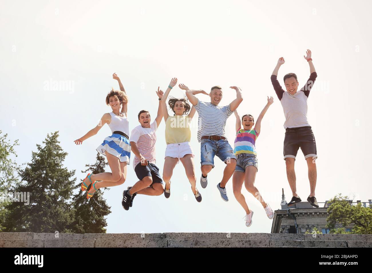 Group of happy teenagers jumping on street Stock Photo - Alamy