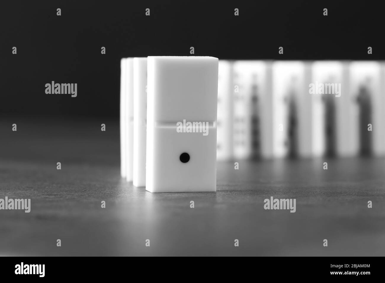 Line of dominoes standing on gray background Stock Photo - Alamy