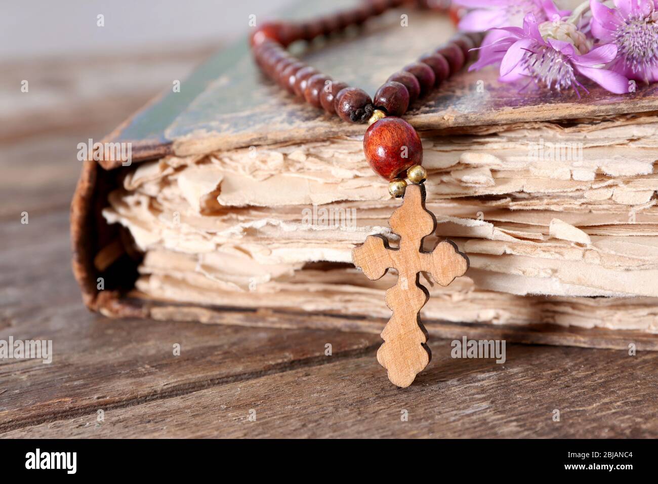 Wooden cross with flowers and old book, closeup Stock Photo - Alamy