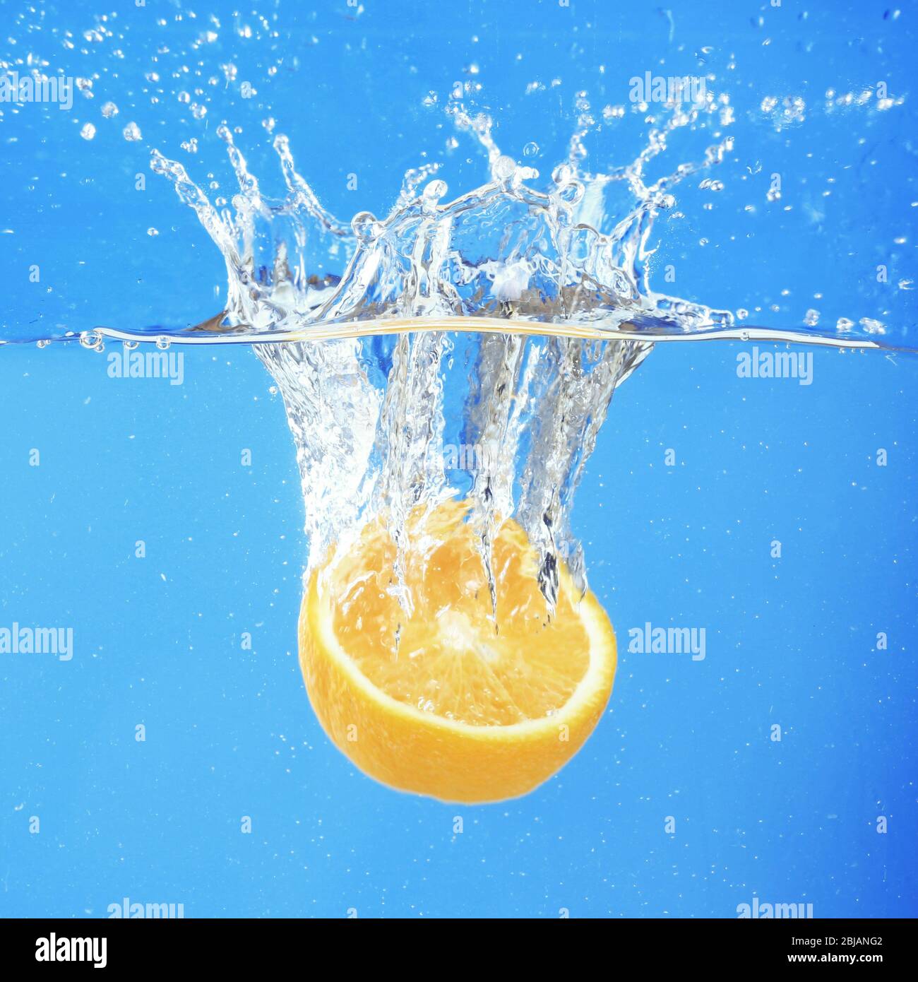 Fresh orange falling in water on blue background Stock Photo - Alamy