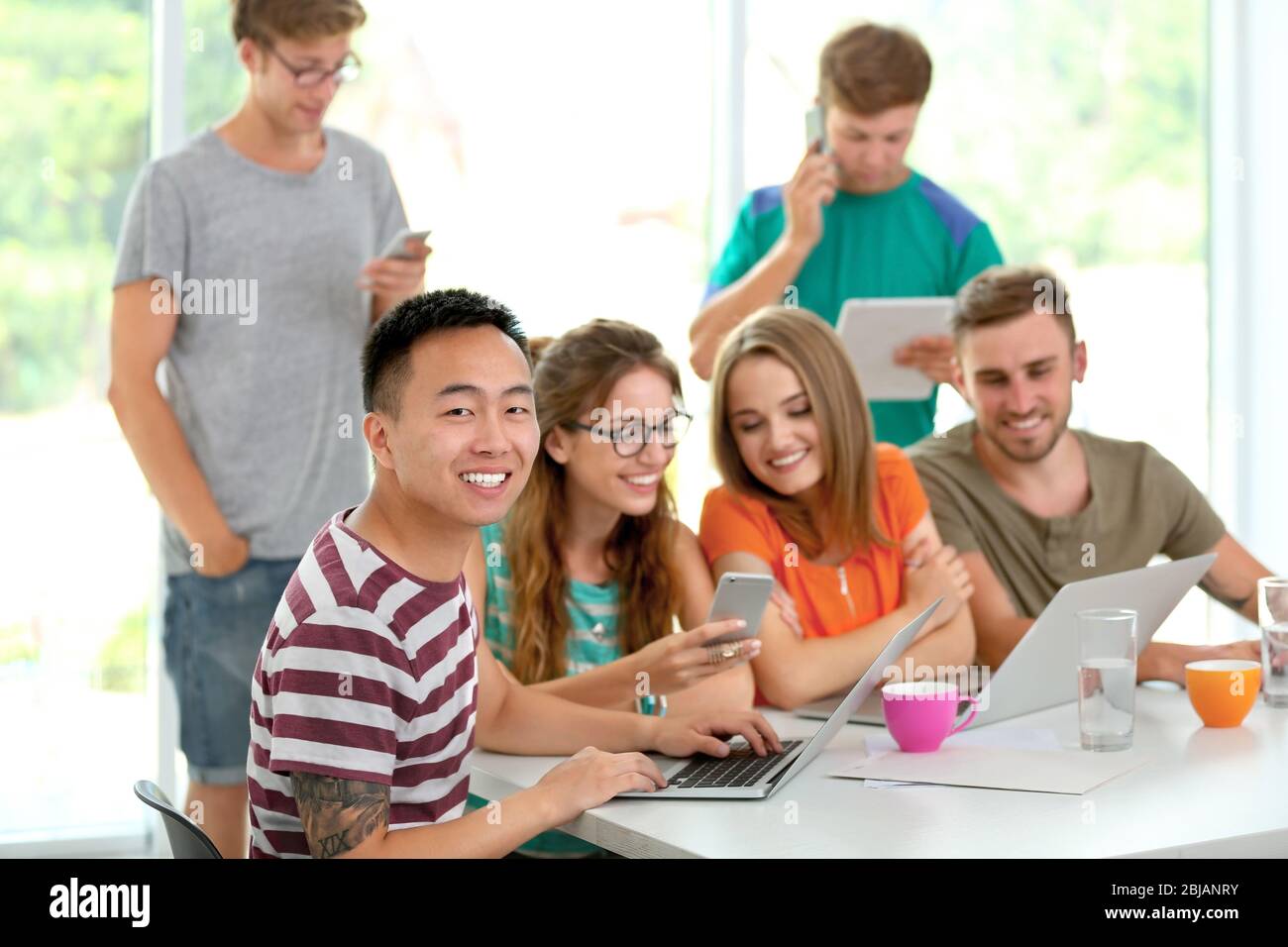 Young people with gadgets hanging out together Stock Photo - Alamy