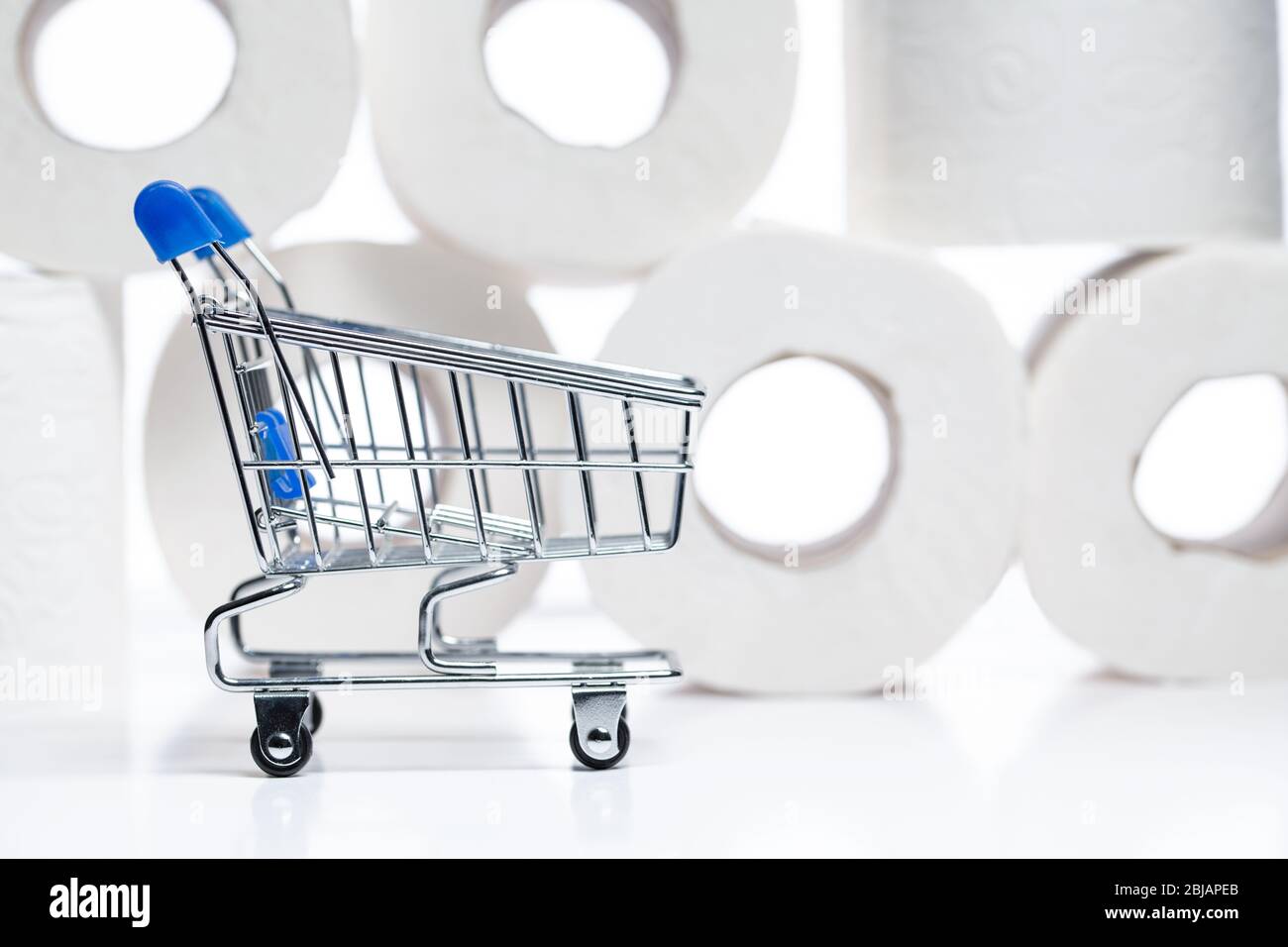 Grocery shopping cart with Toilet Paper rolls behind. Concept of lack ...