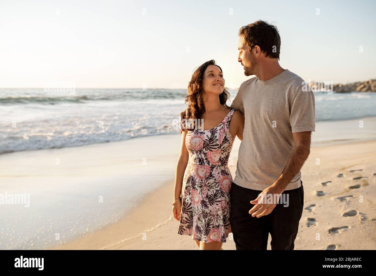 Affectionate young couple walking together along a sandy beach Stock ...