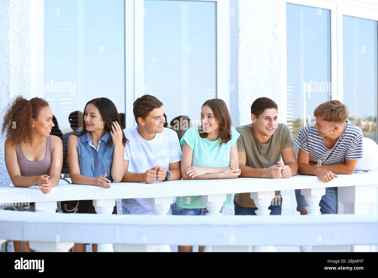 Happy friends on balcony Stock Photo - Alamy