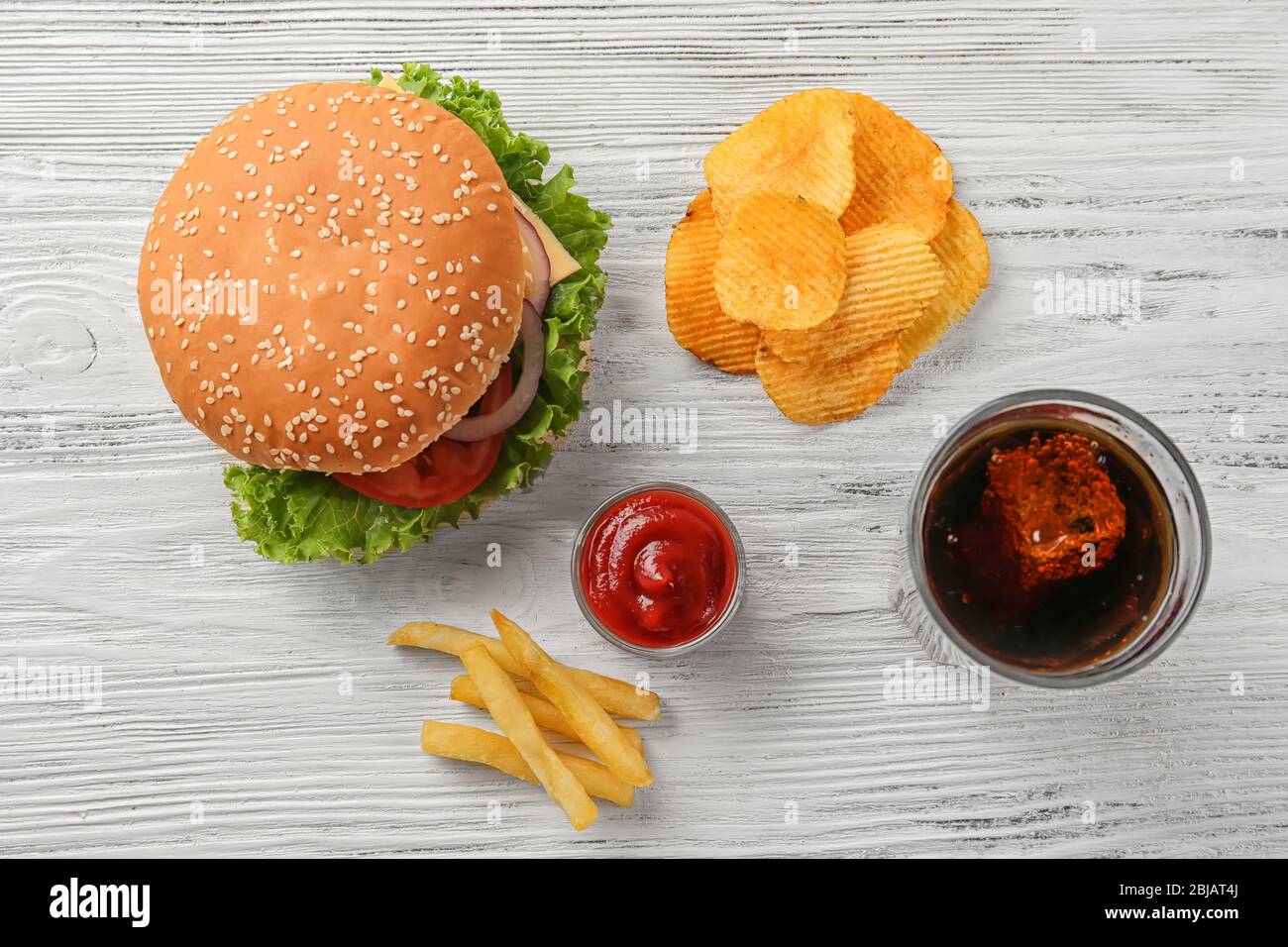 Tasty cheeseburger with snack and coke on wooden table Stock Photo - Alamy