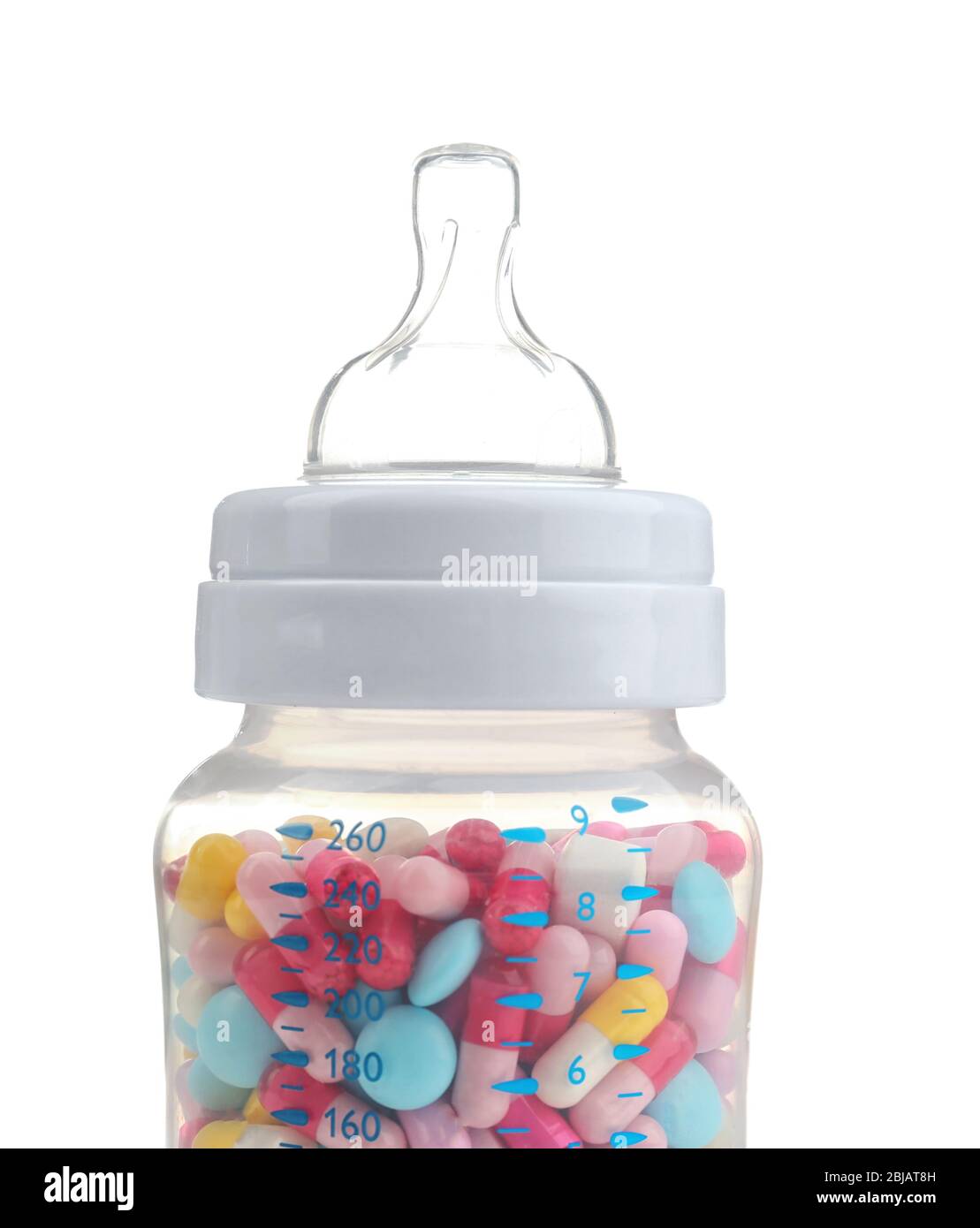 Baby bottle full of colourful pills isolated on white Stock Photo - Alamy