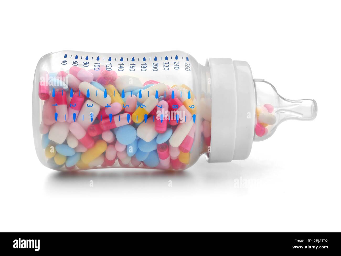 Baby bottle full of colourful pills isolated on white Stock Photo - Alamy