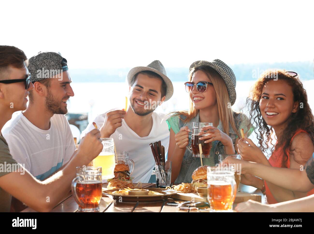 Group of friends hanging out together outdoors Stock Photo - Alamy