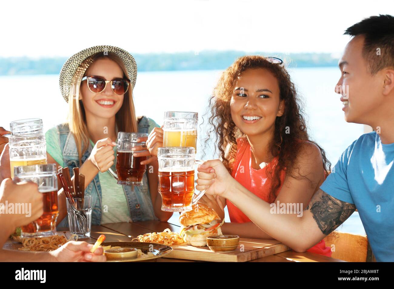Group of friends hanging out together outdoors Stock Photo - Alamy