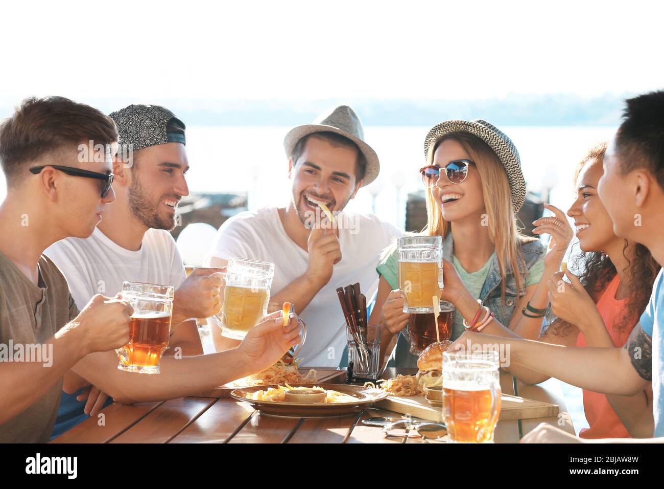 Group of friends hanging out together outdoors Stock Photo - Alamy