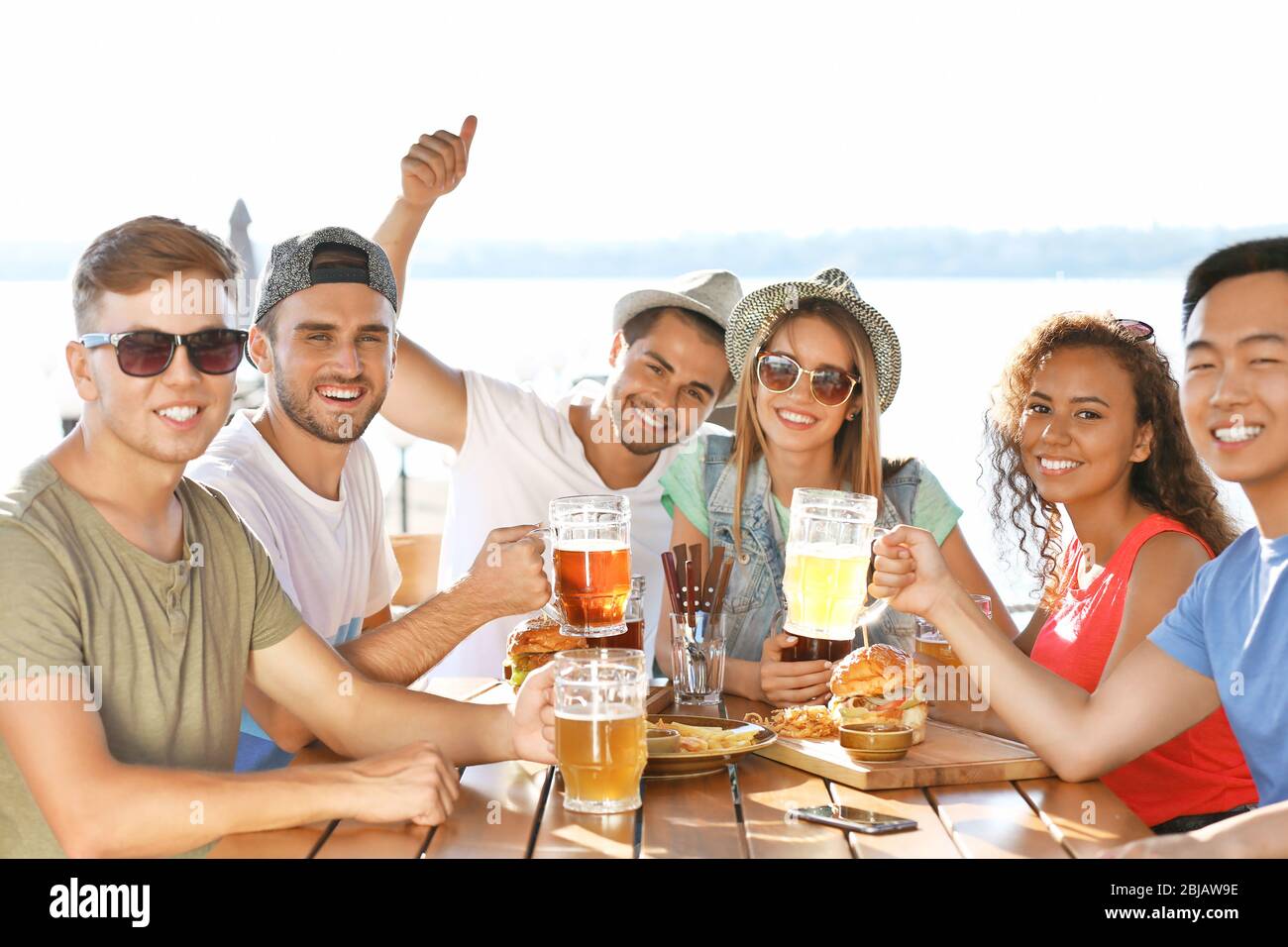 Group of friends hanging out together outdoors Stock Photo - Alamy