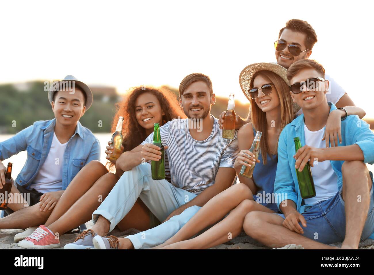 Group of friends hanging out with beer at the beach Stock Photo - Alamy