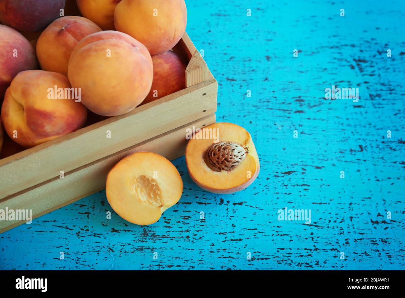 Fresh peaches in a box on a color background Stock Photo - Alamy