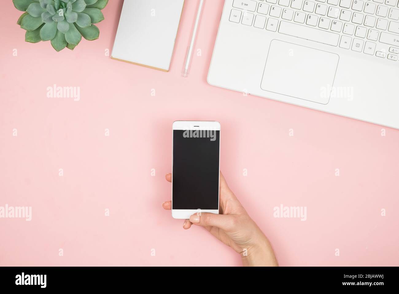 Womens home workspace. Girl Blogger works with phone and laptop ...