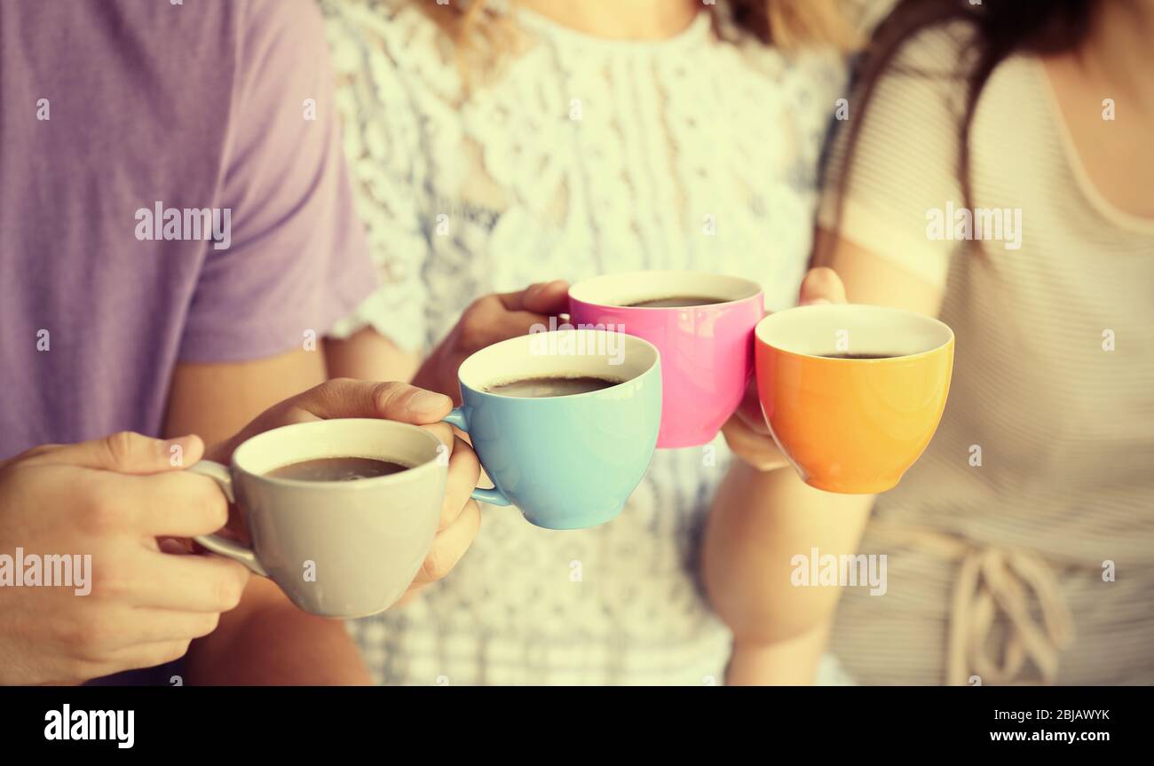 Group of people holding cups of coffee together Stock Photo - Alamy