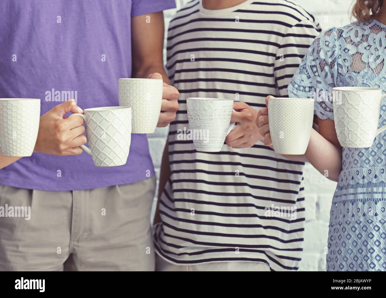 Group of people holding cups of coffee together Stock Photo - Alamy
