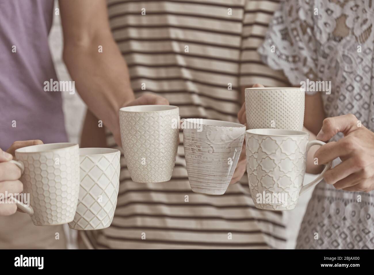 Group of people holding cups of coffee together Stock Photo - Alamy