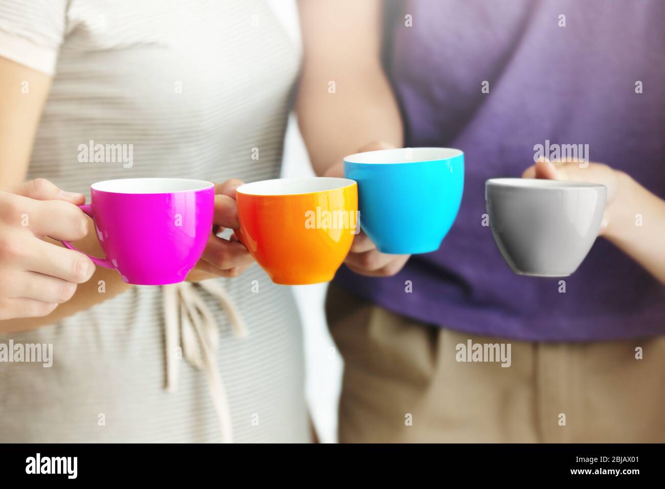 Group of people holding cups of coffee together Stock Photo - Alamy
