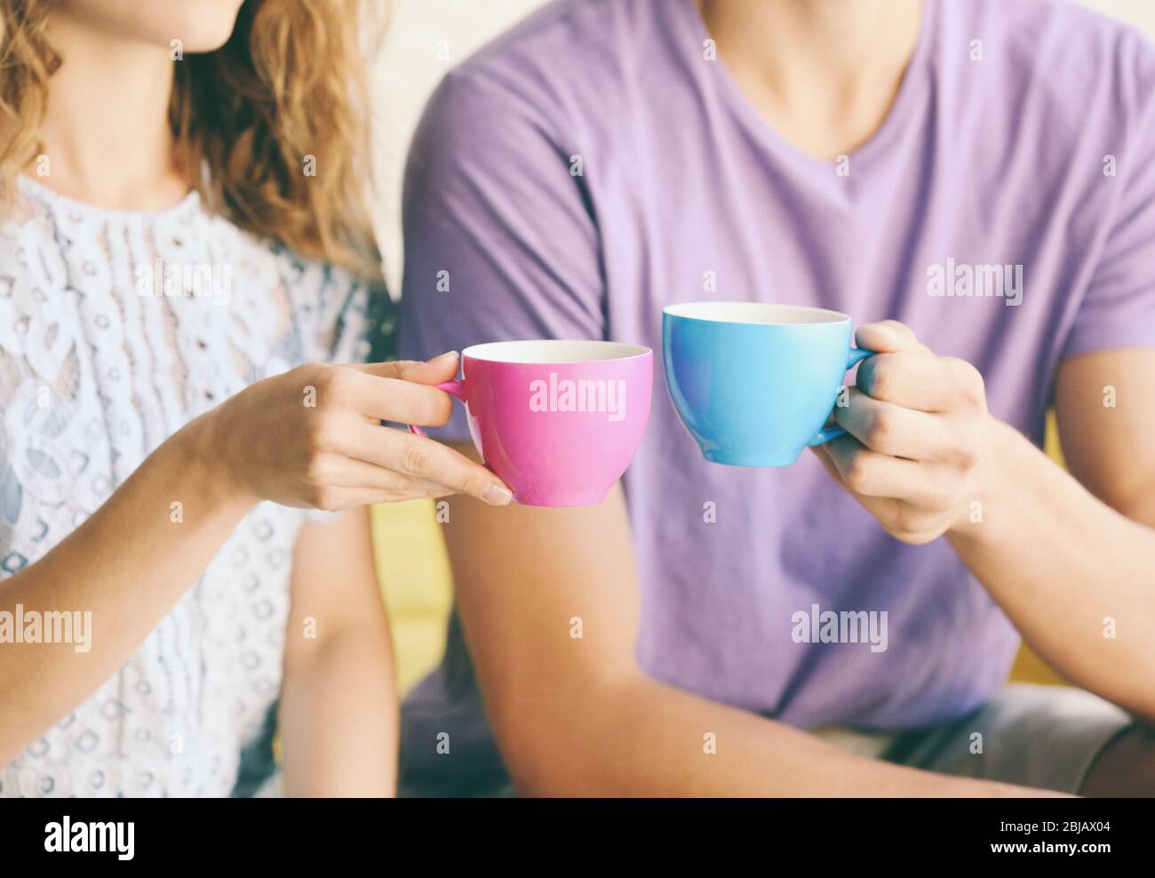 Couple holding cups of coffee together Stock Photo - Alamy