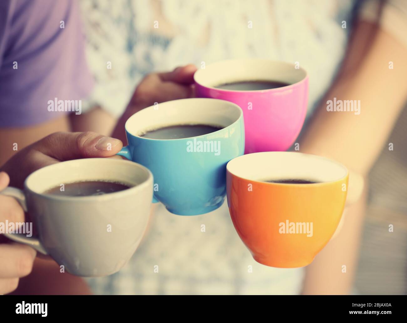 Group of people holding cups of coffee together Stock Photo - Alamy