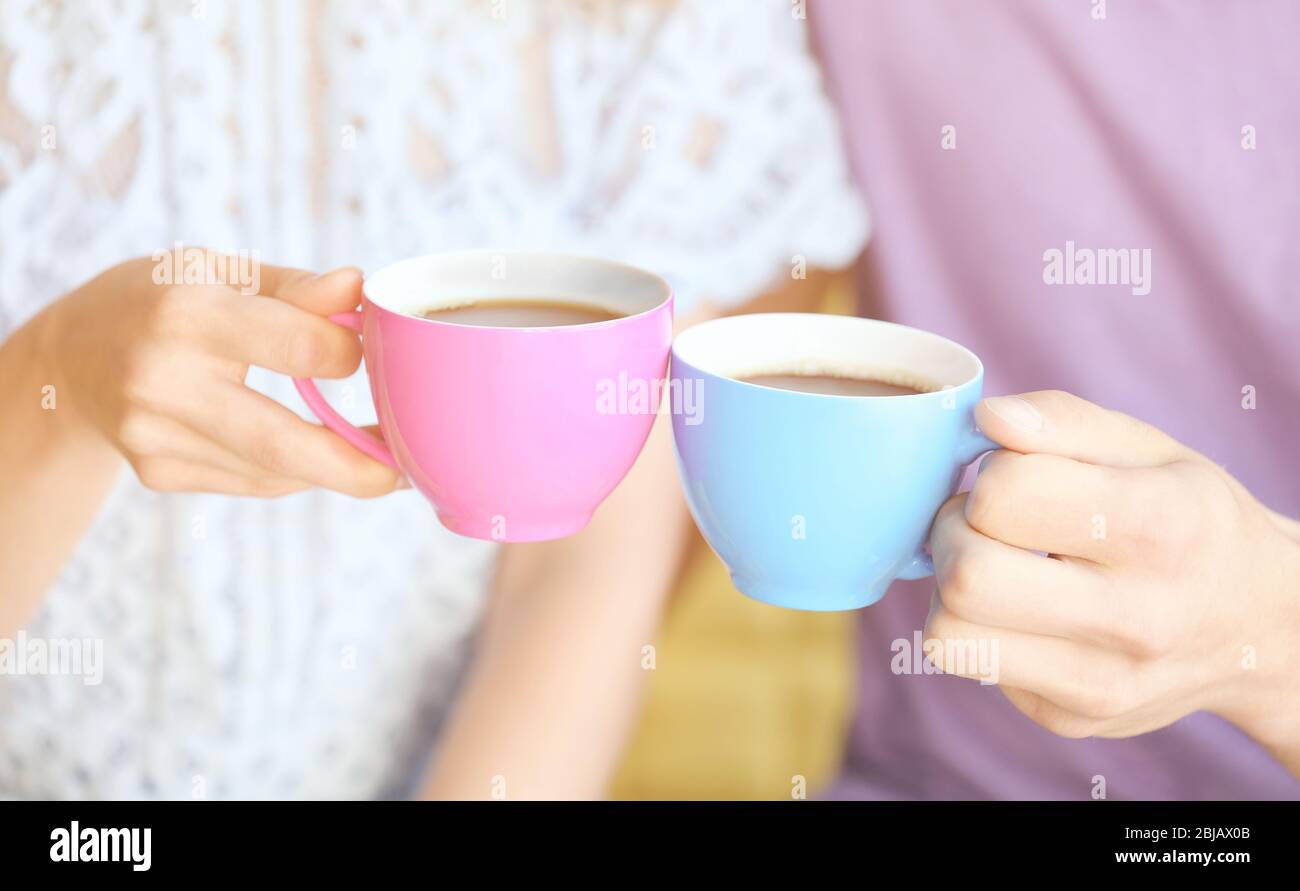 Couple holding cups of coffee together Stock Photo - Alamy