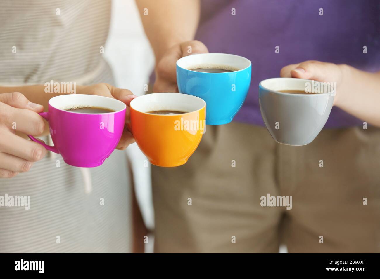 Group of people holding cups of coffee together Stock Photo - Alamy