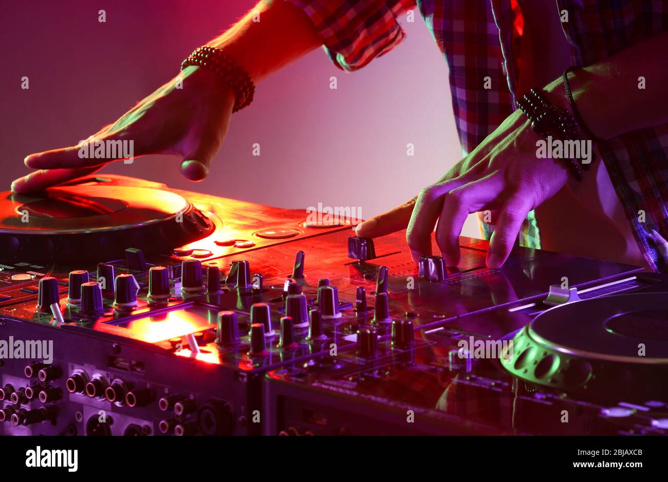 DJ mixing tracks on a mixer in a nightclub Stock Photo - Alamy