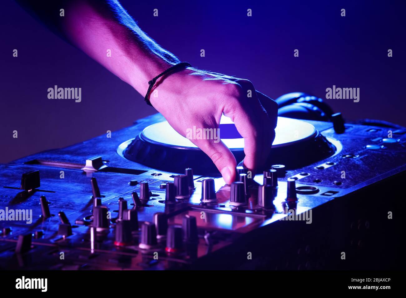 DJ mixing tracks on a mixer in a nightclub Stock Photo - Alamy