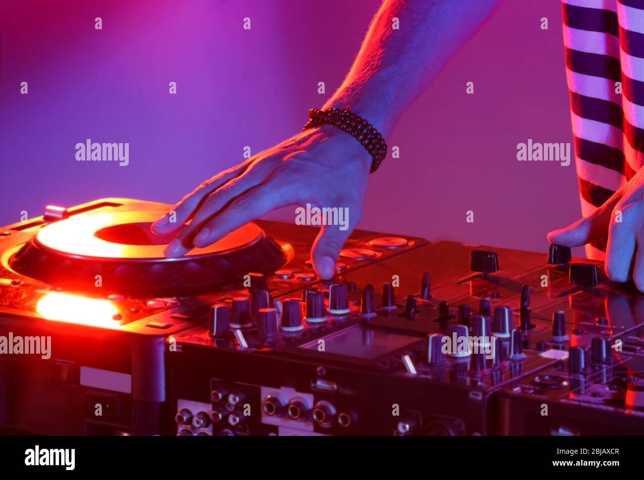 DJ mixing tracks on a mixer in a nightclub Stock Photo - Alamy