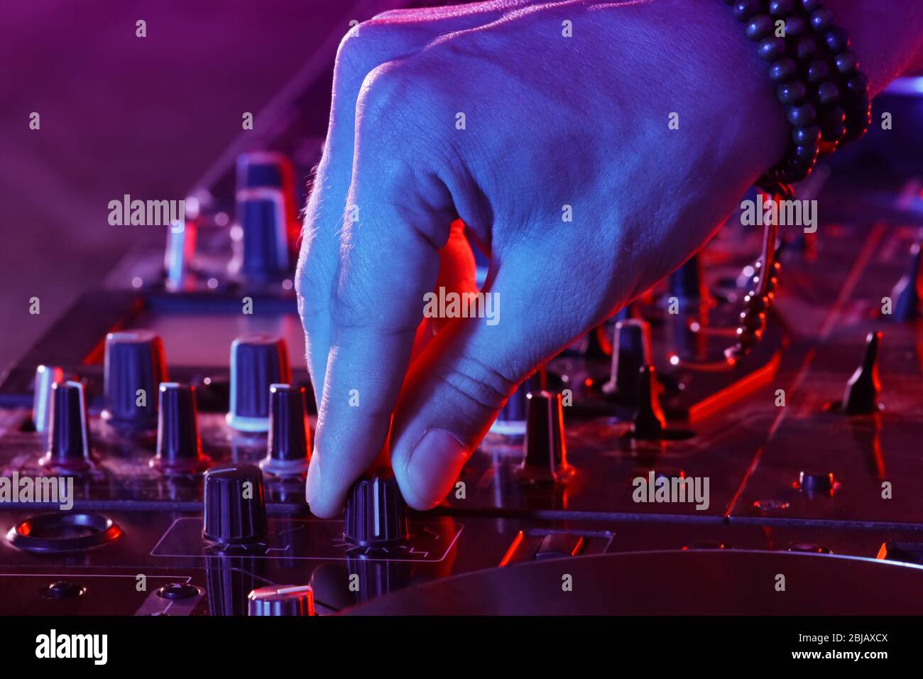 DJ mixing tracks on a mixer in a nightclub Stock Photo - Alamy