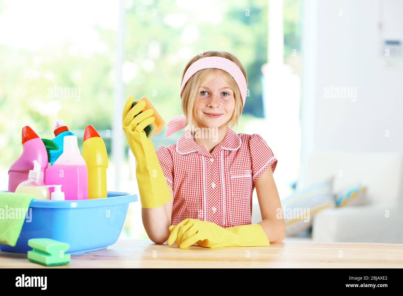 Little girl with bucket full of cleaning utensils Stock Photo - Alamy