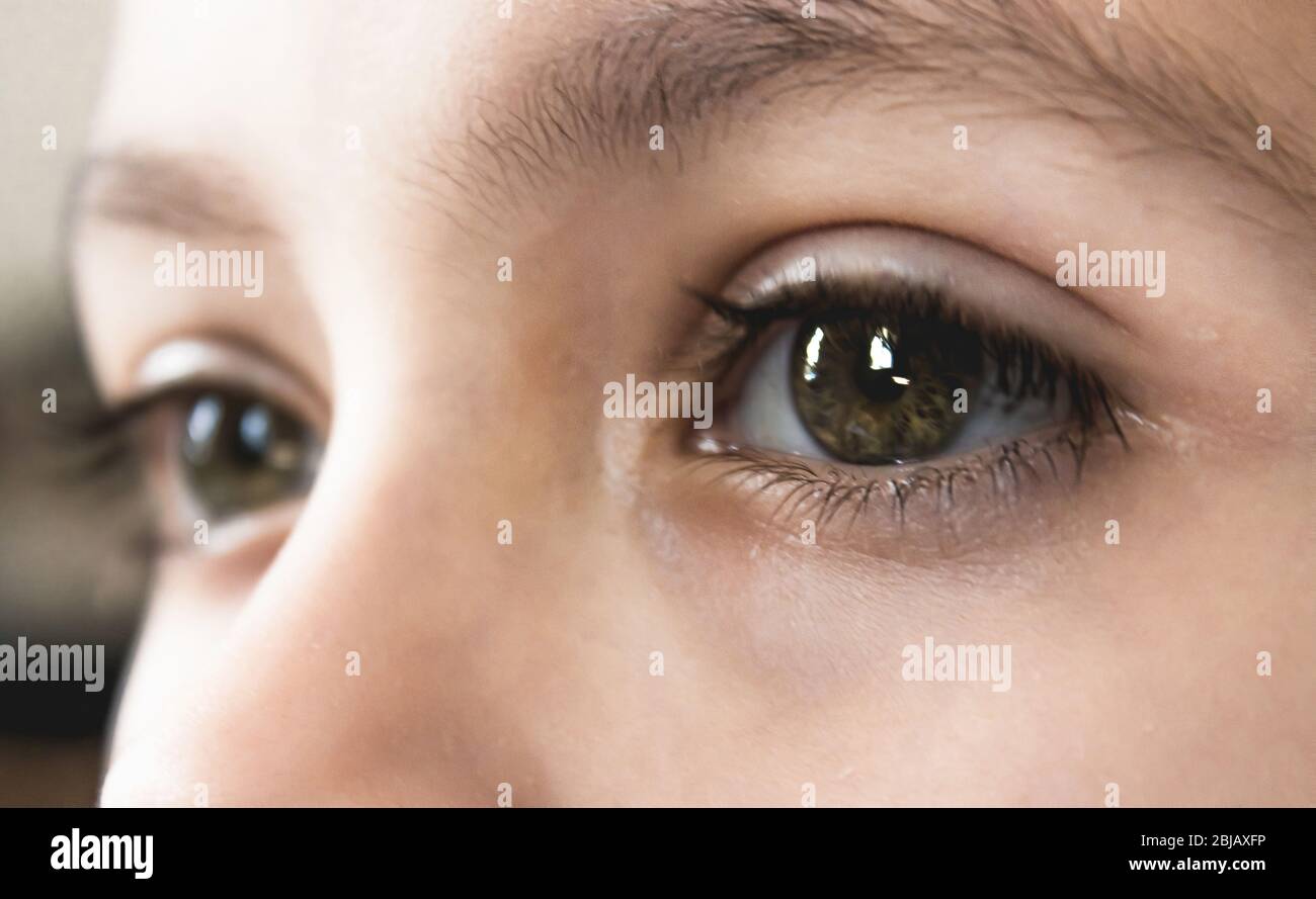Thoughtful eyes of a teenage boy man close-up. The boy looks into the ...