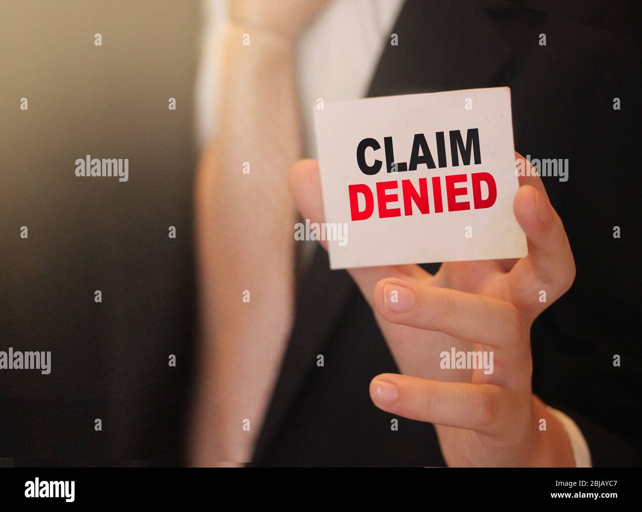 Claim Denied words on a card in hand of businessman. Business agreement ...