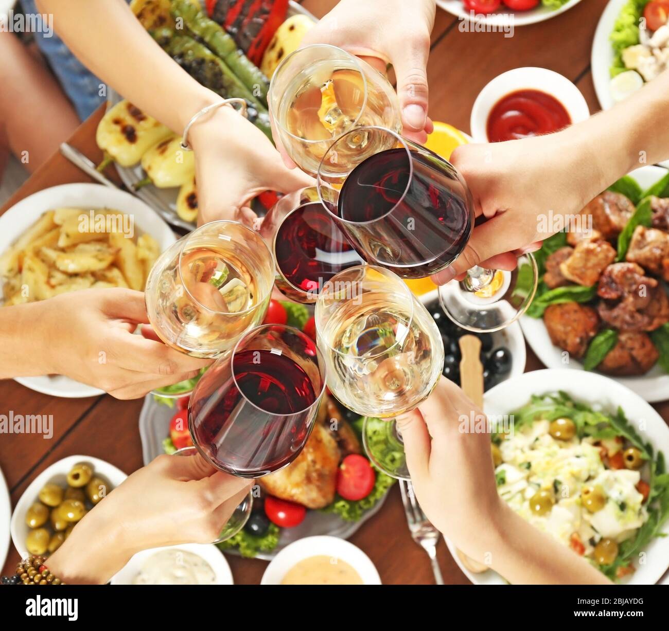 Friends cheering with glasses of wine in restaurant Stock Photo - Alamy
