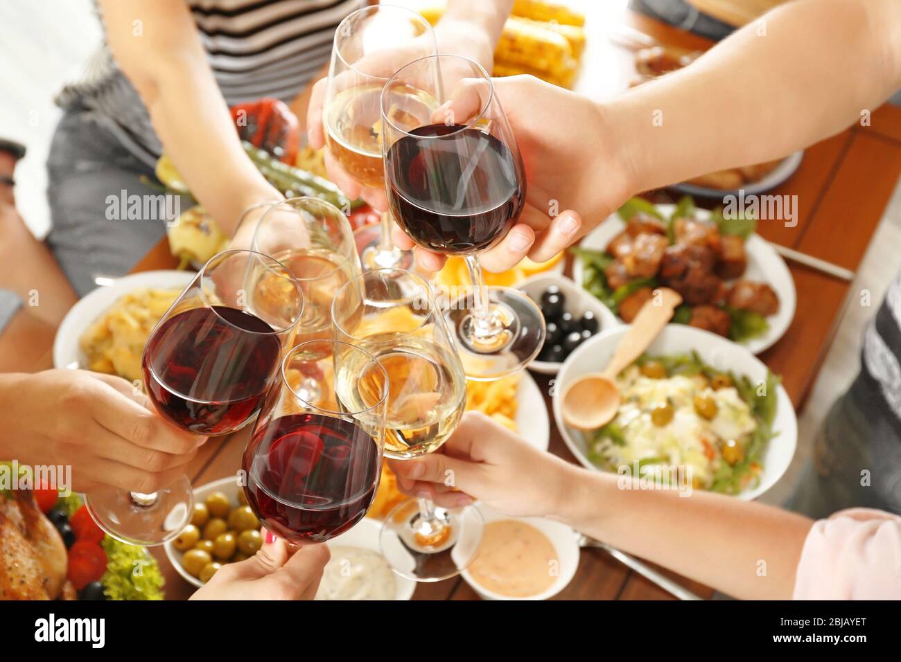 Friends cheering with glasses of wine in restaurant Stock Photo - Alamy