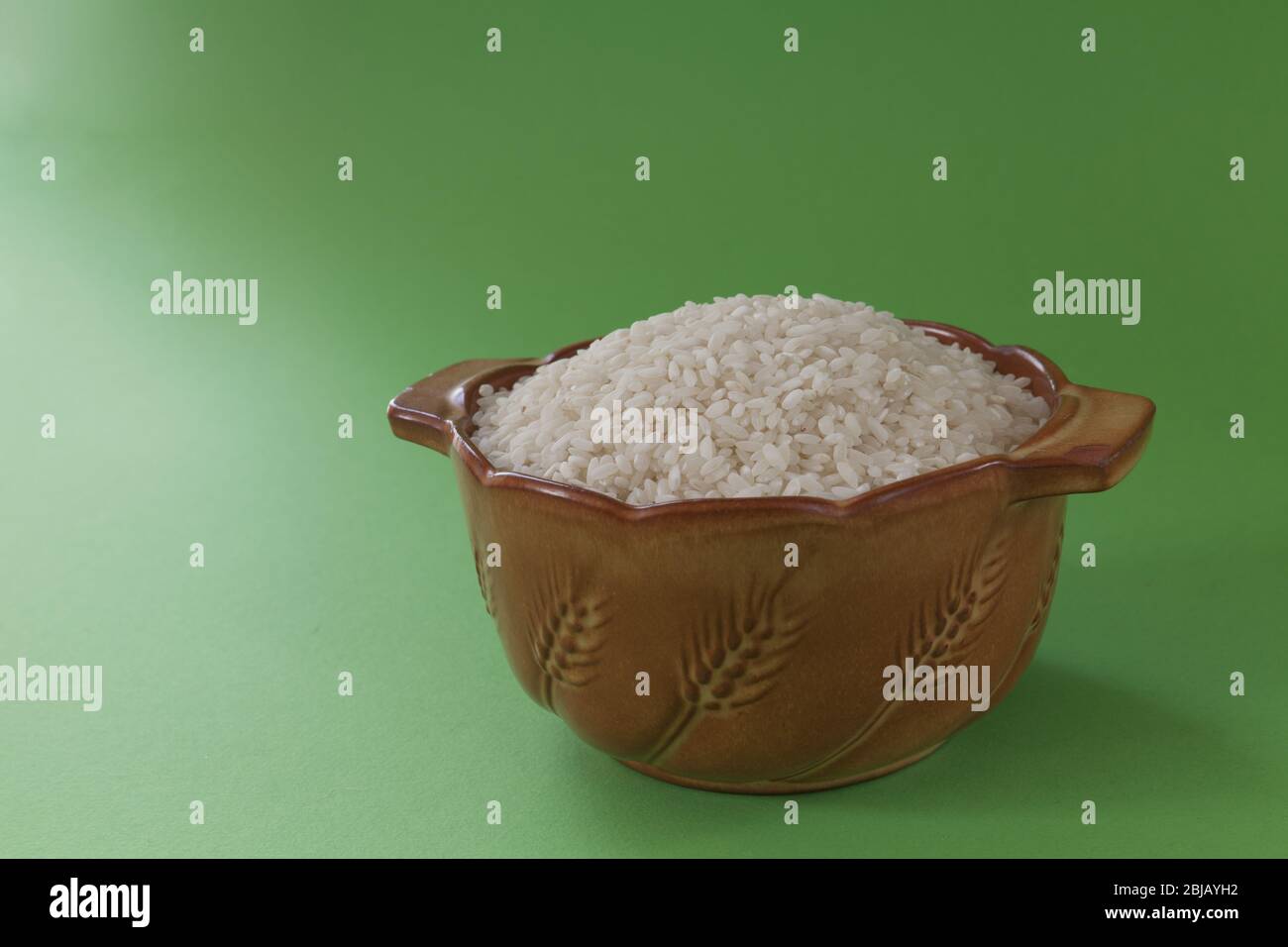 white rice in ceramic bowl, green background Stock Photo - Alamy