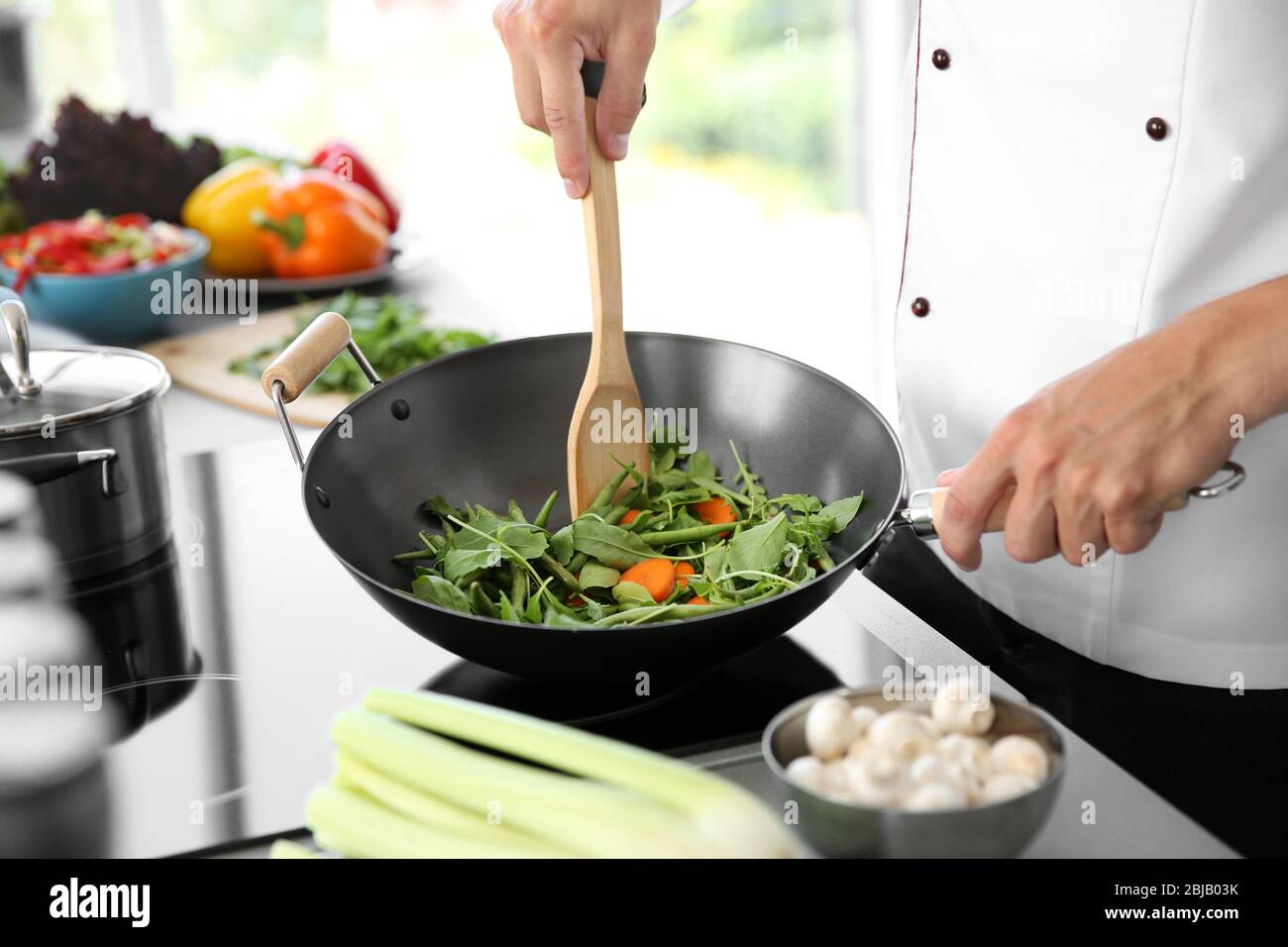 Male hand mixing vegetables in pan closeup Stock Photo - Alamy