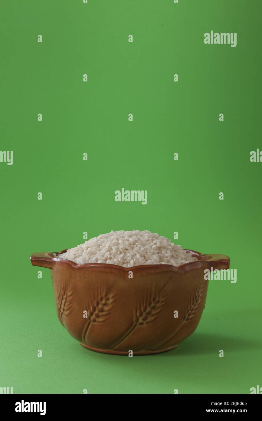 white rice in ceramic bowl, green background Stock Photo - Alamy